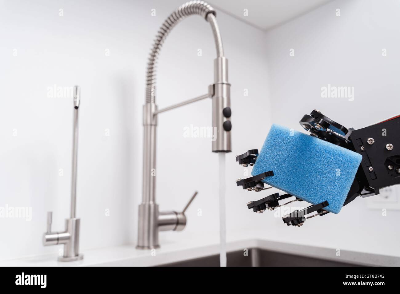 Real robot's hand holding sponge for dishwashing in stainless sink and ...