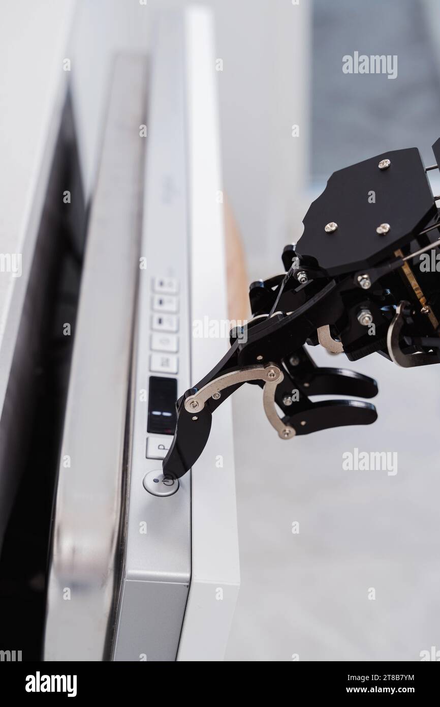 Real robot hand pushing button on dishwasher. Concept of Artificial ...