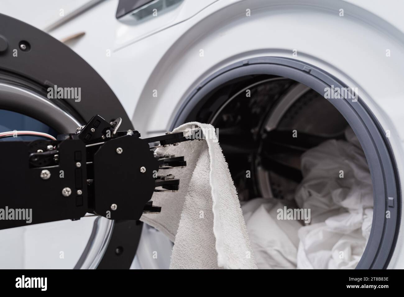 Real robot's hand and washing machine. Concept of Artificial ...