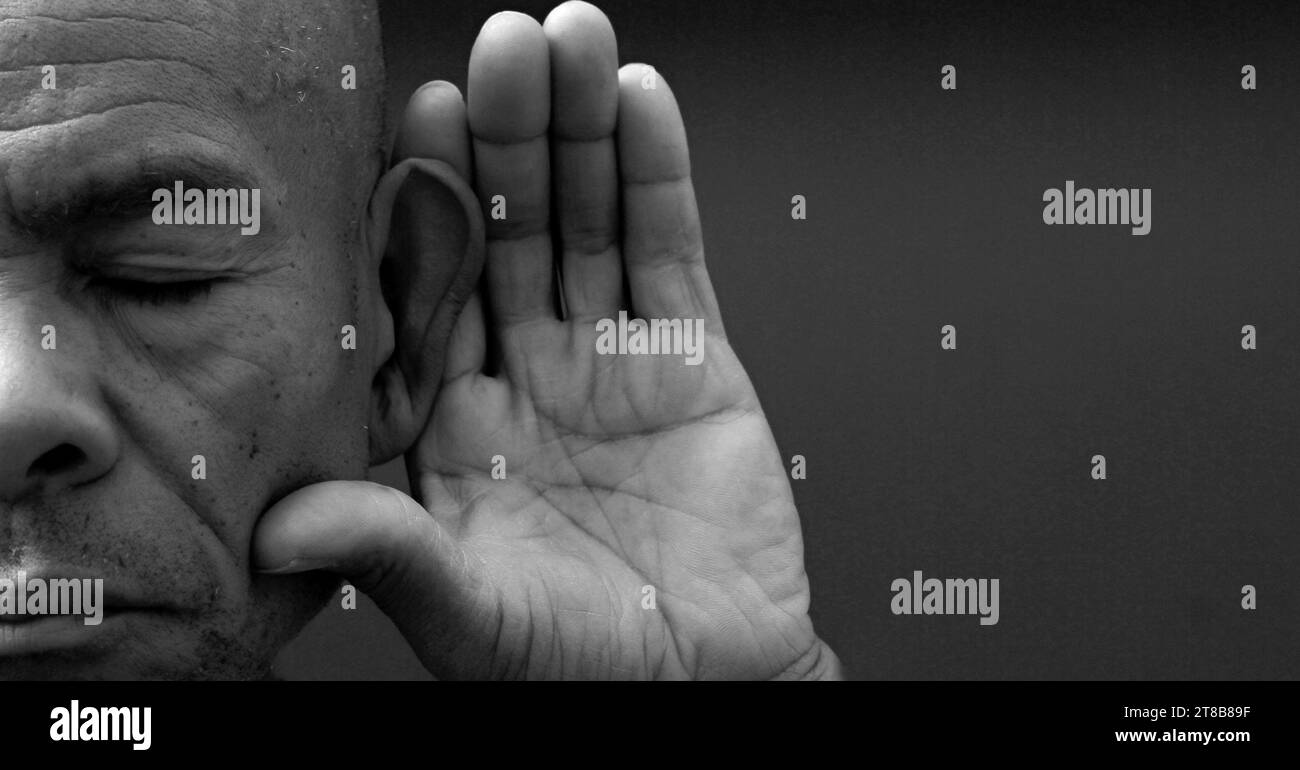 suffering from deafness and hearing loss on grey black background with ...