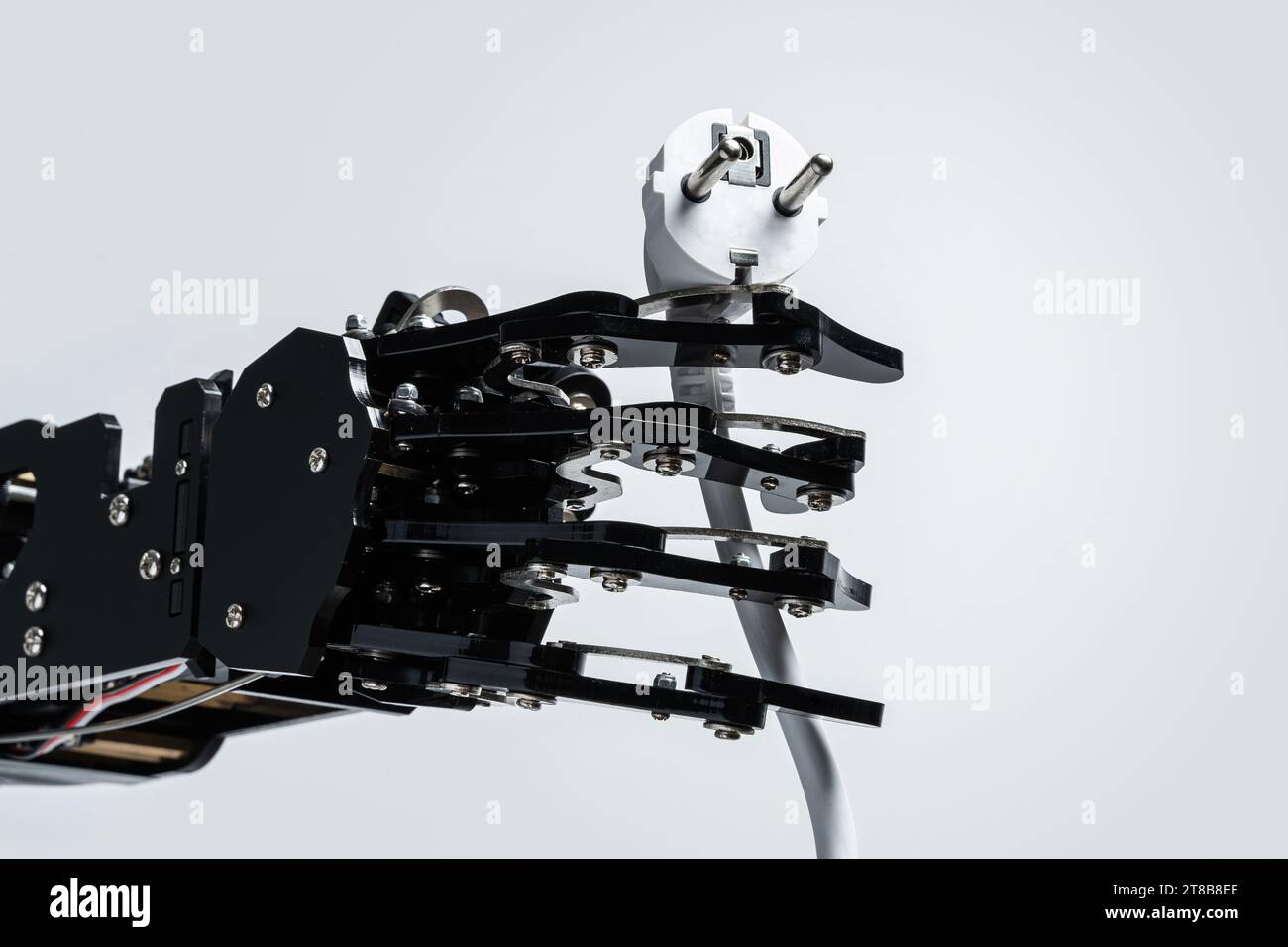 Real robotic hand with power plug. Concepts of AI takeover and ...