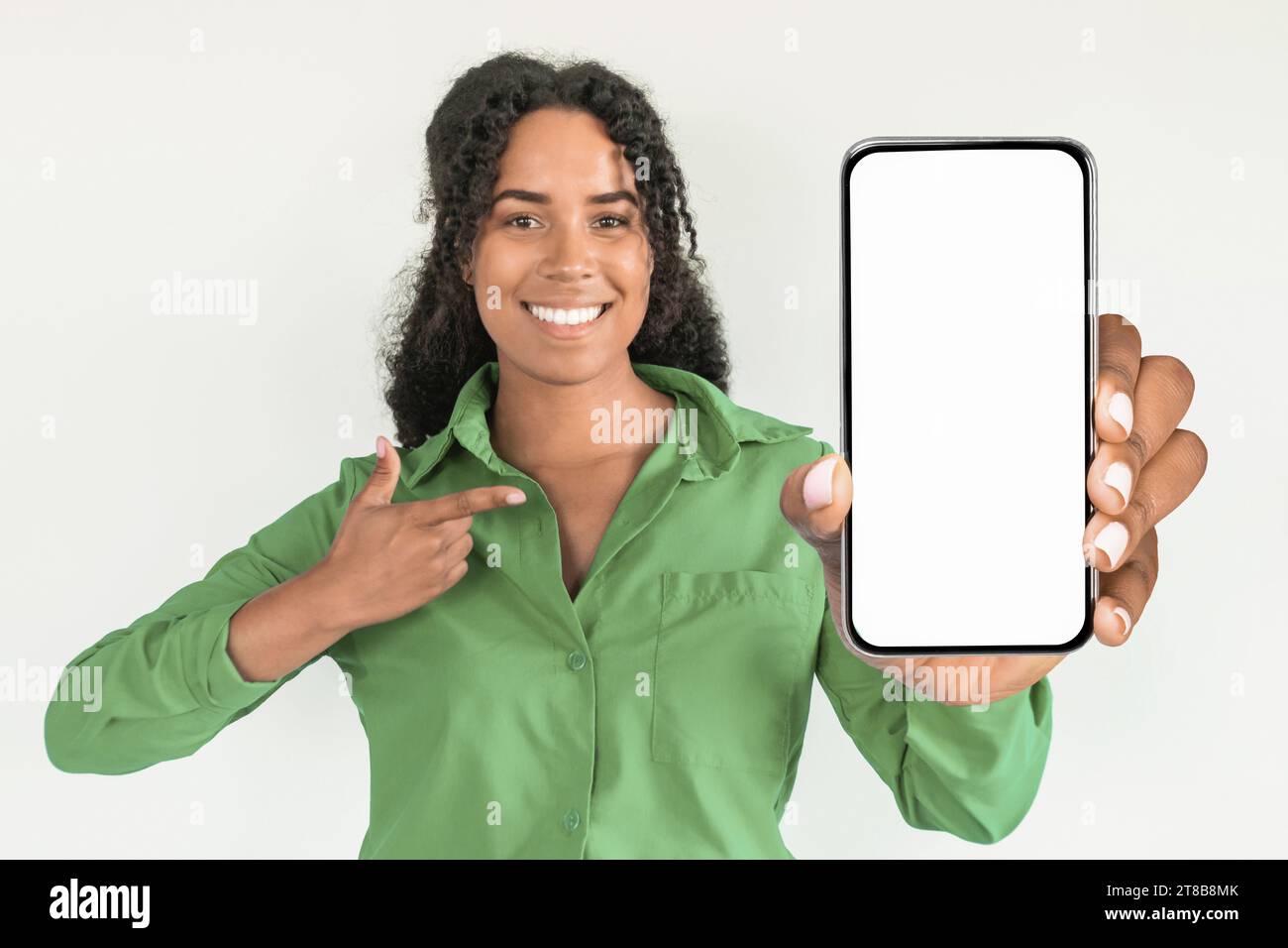 black lady points at large phone display on white background Stock ...
