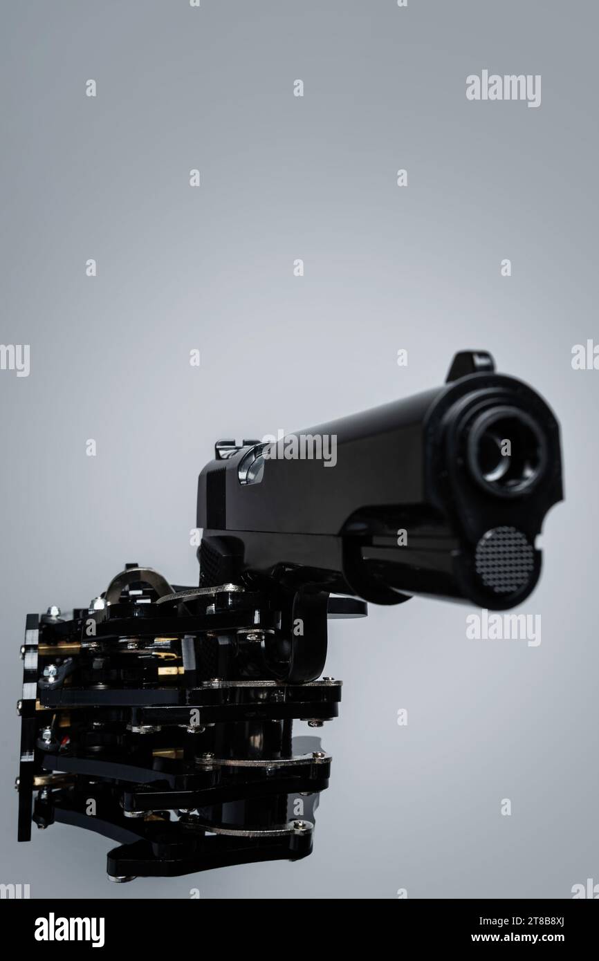 Real robot's hand with handgun. Concept of AI takeover and ...