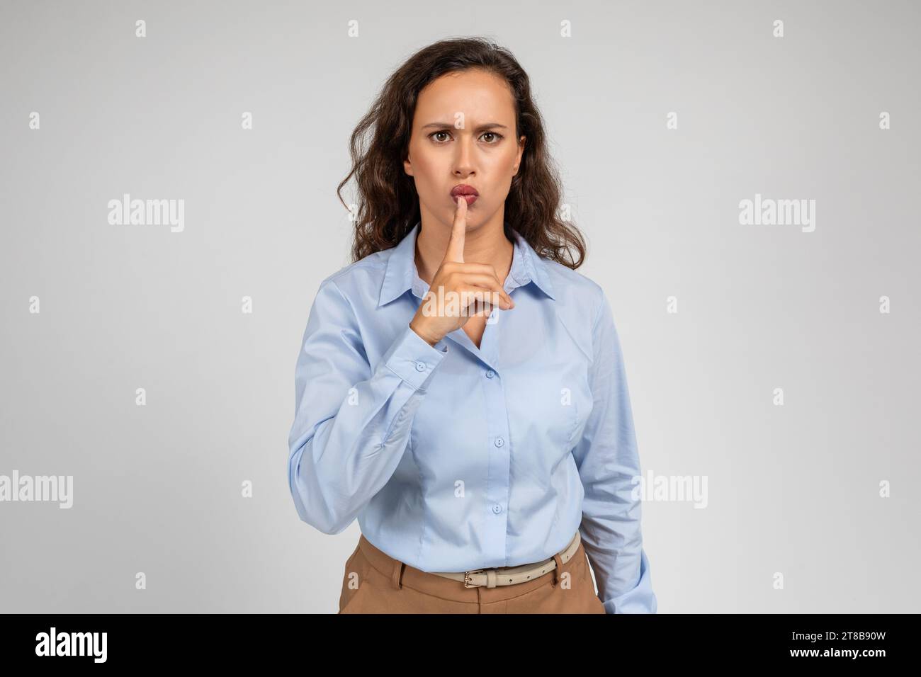 Strict sad angry young european businesswoman put finger to lips, make ...