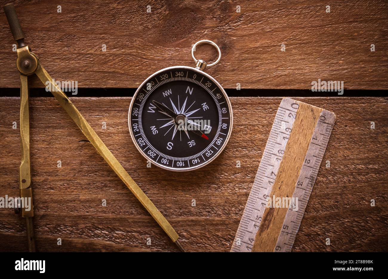 Vintage ruler, drawing and navigational Compass on a rustic wooden ...