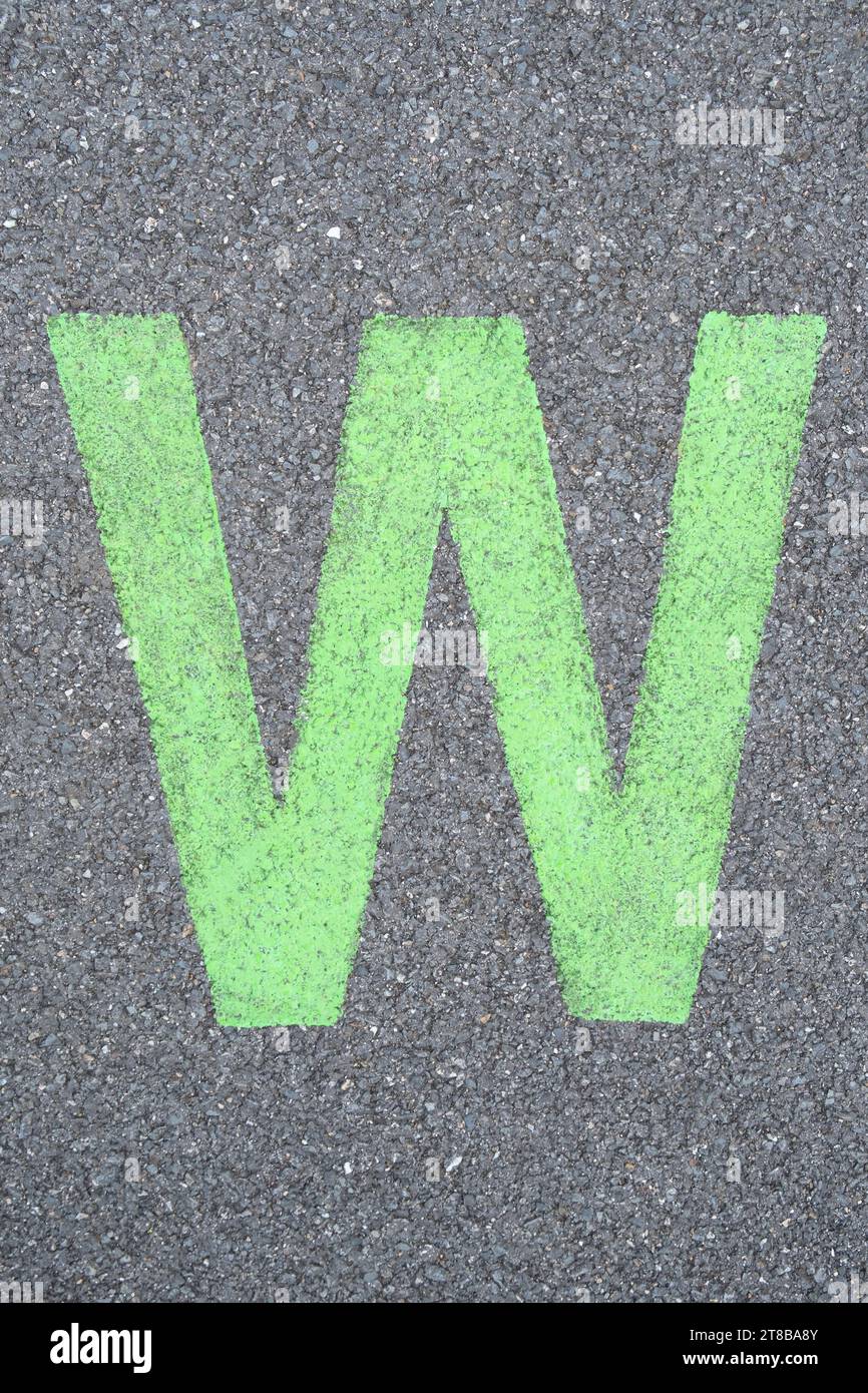 The Letter W is drawn with color paint on asphalt. a children's ...