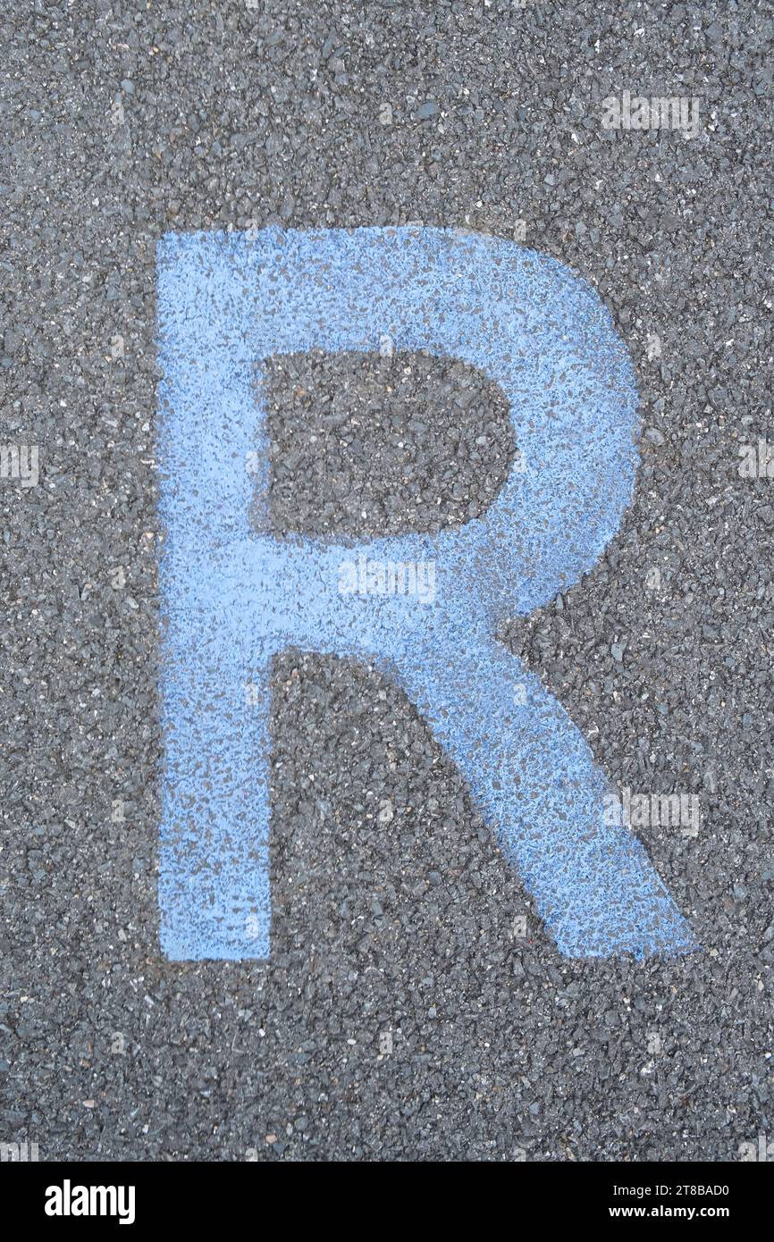 The Letter R is drawn with color paint on asphalt. a children's ...