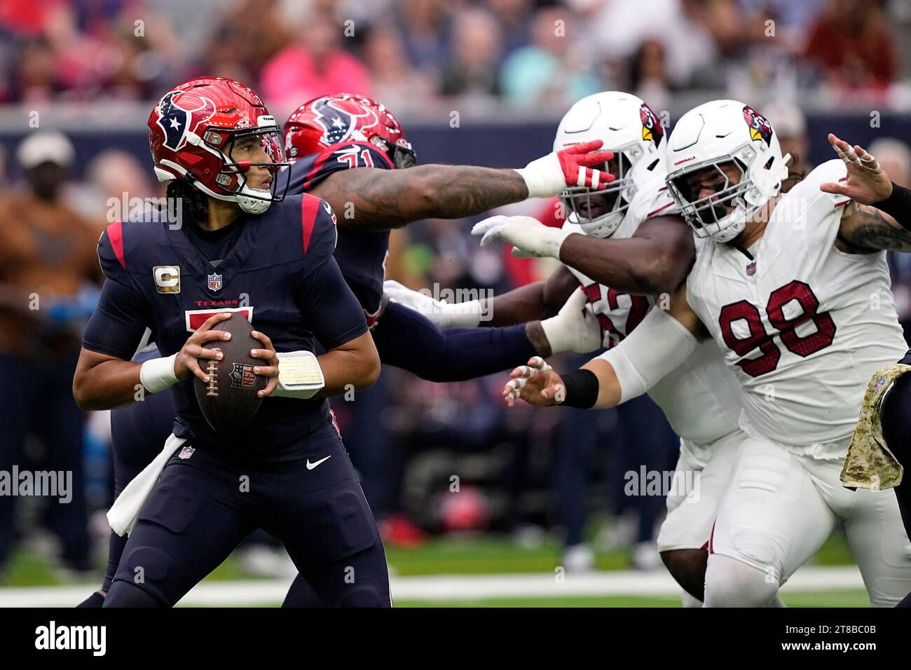 Houston Texans quarterback C.J. Stroud, left, prepares to throw a pass under pressure from ...