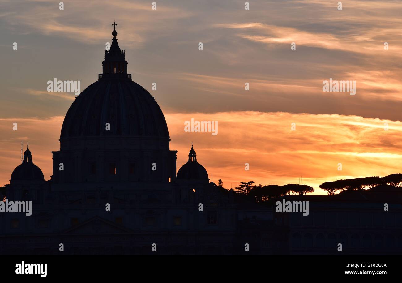 The domes of St Peter's Basilica in silhouette against a vivid summer ...