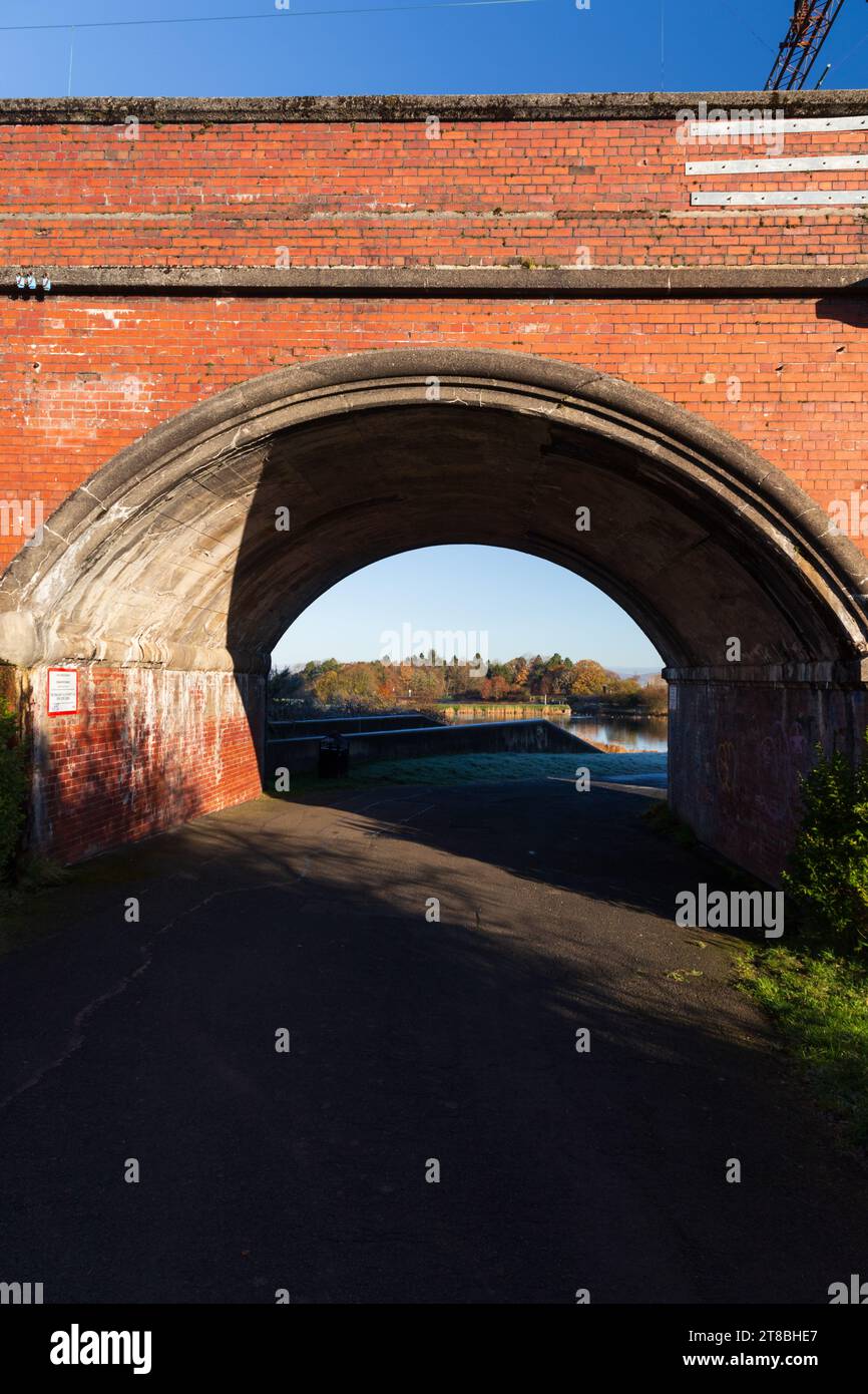 A railway bridge over a reservoir in Scotland on a clear winters ...