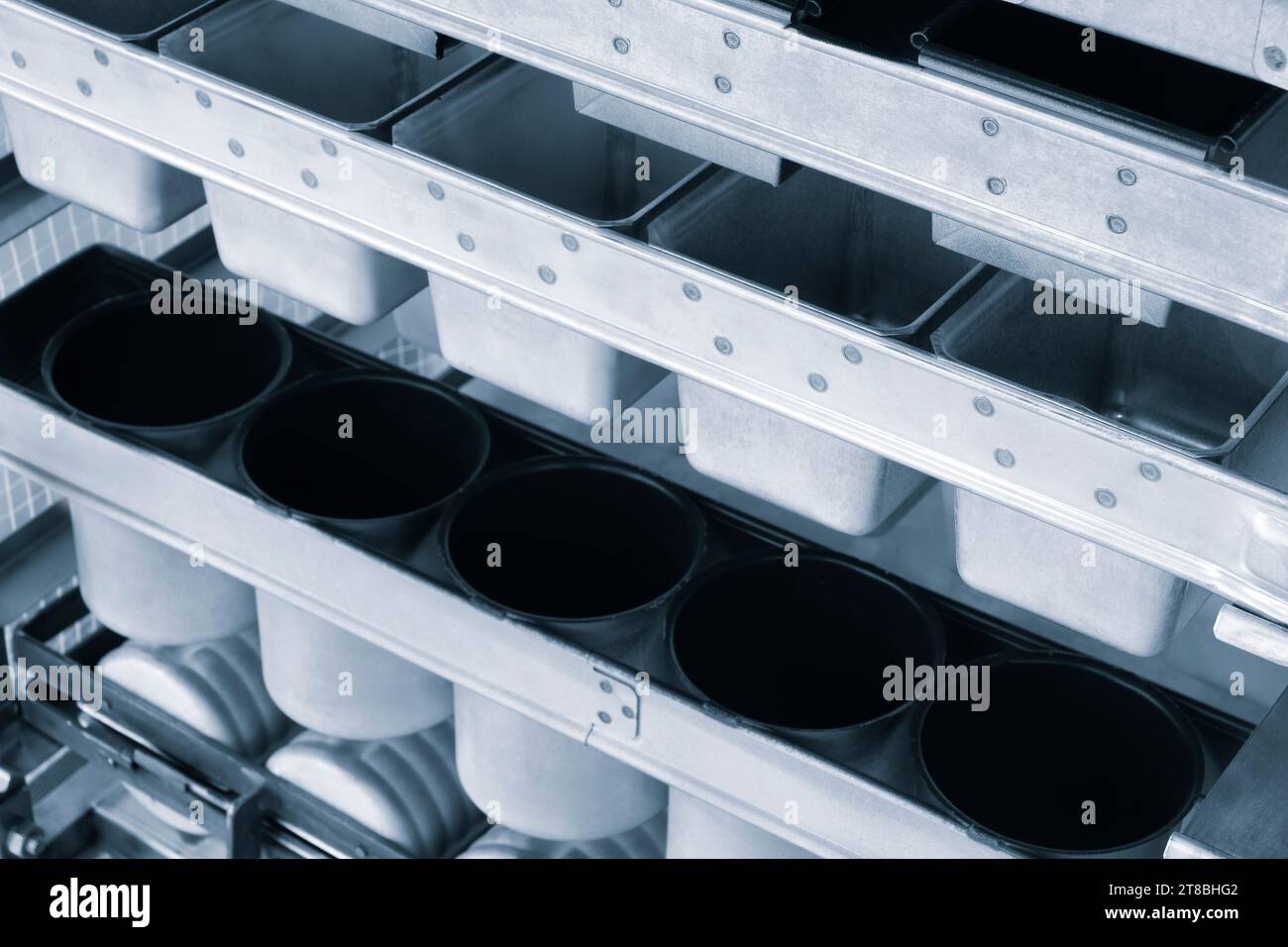 Rack with metal containers for cooking bakery food Stock Photo - Alamy