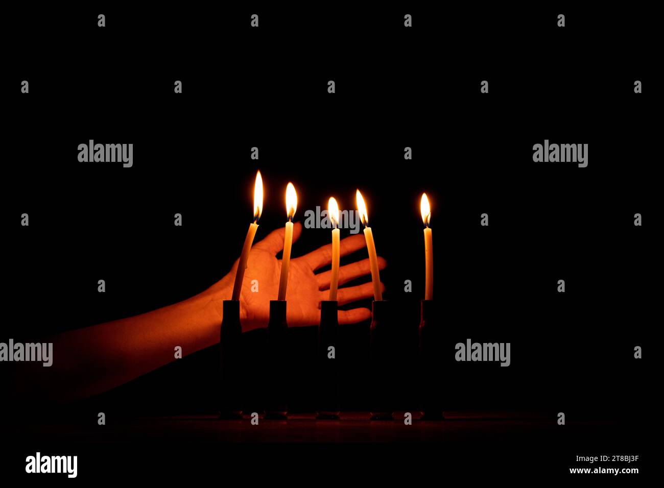 A woman s hand next to shell casings in which candles are burning in ...