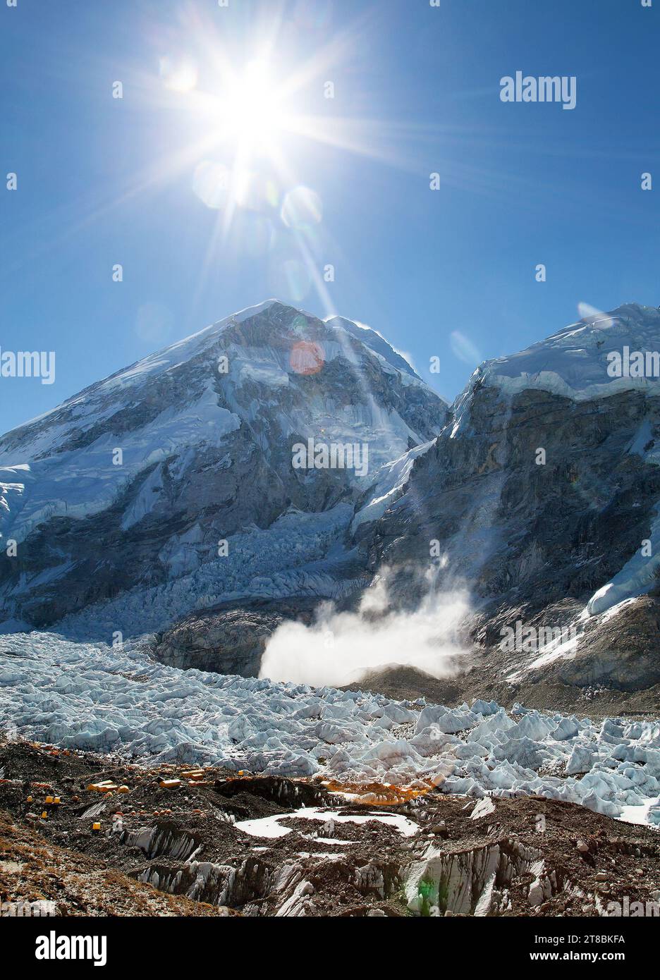 snow ice avalanche falling in sunshine from Mount Nuptse on Kumbu ...
