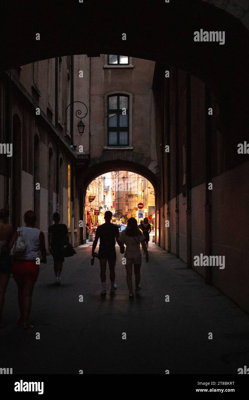 A couple walks under an arch in Lyon, France Stock Photo - Alamy