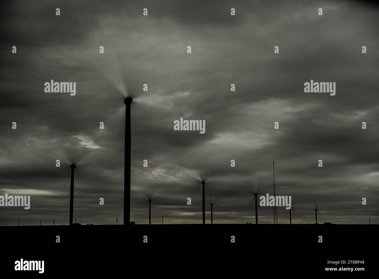 Dreamy vision of renewable energy producing wind turbines on a gray day ...
