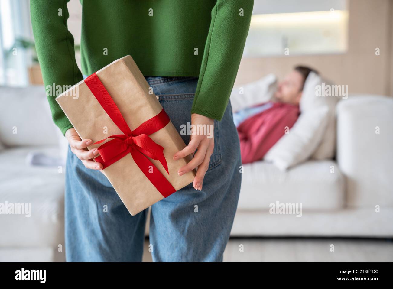 Gift box with ribbon for holiday. Woman holding present behind back ...