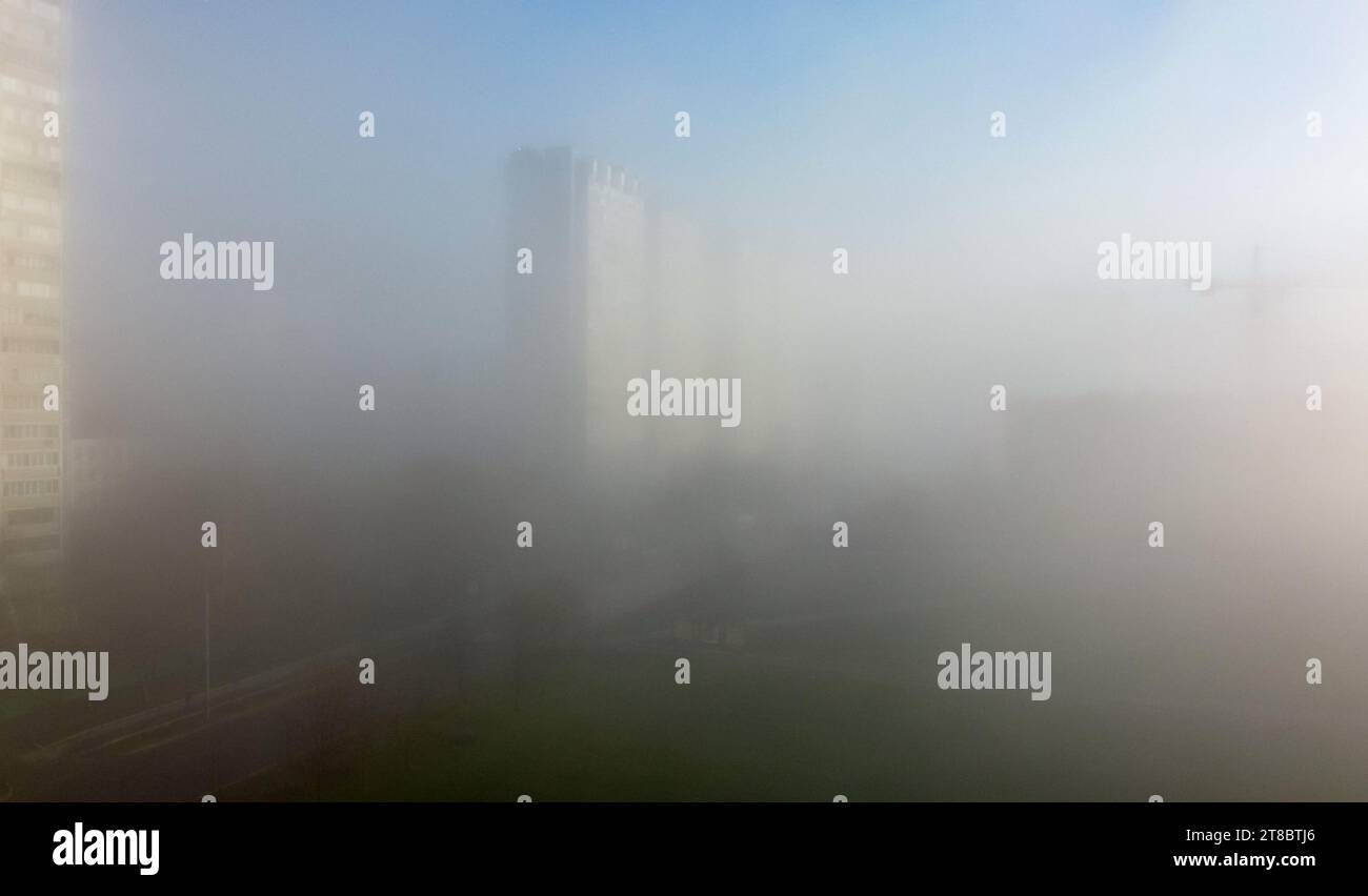 Construction cranes and a multi-storey residential building, shrouded ...