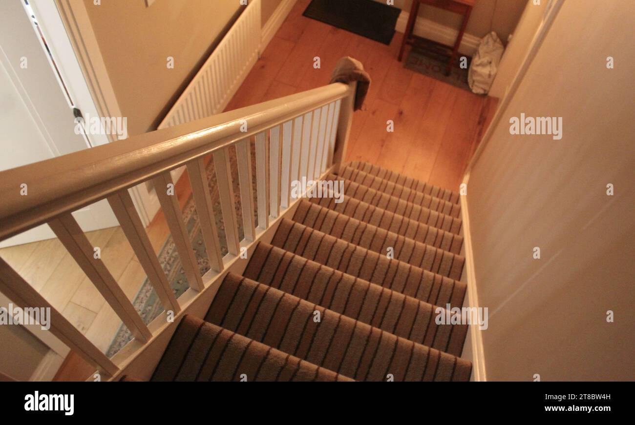 A high angle photo of a staircase leading downward into a hallway at ...