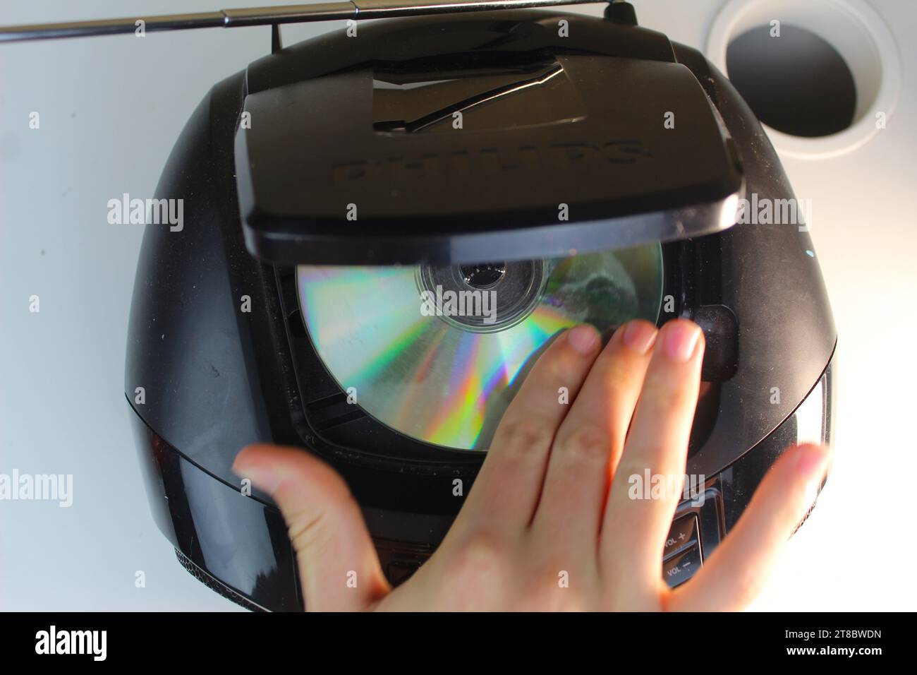 A top down photo of someone slotting a cd into a black cd player on a ...