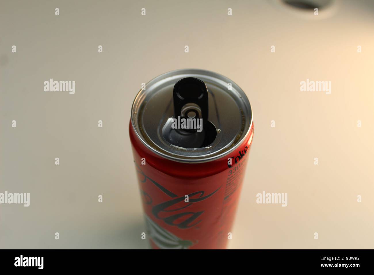 A close up photo of a red and black Coca Cola Zero can on a white desk ...
