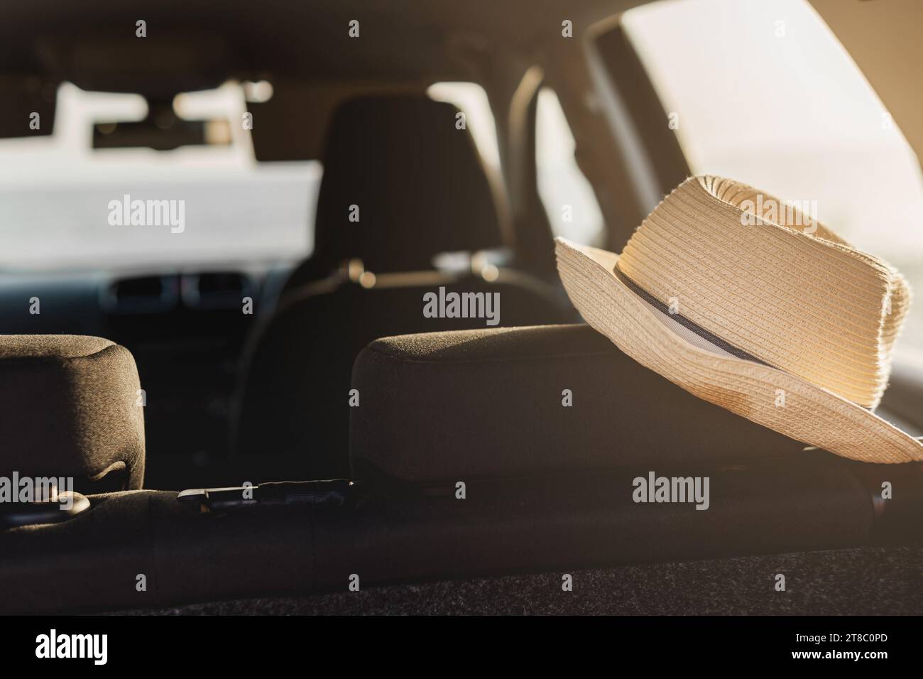 Sraw hat rests on the backseat of a car parked on the beach Stock Photo ...