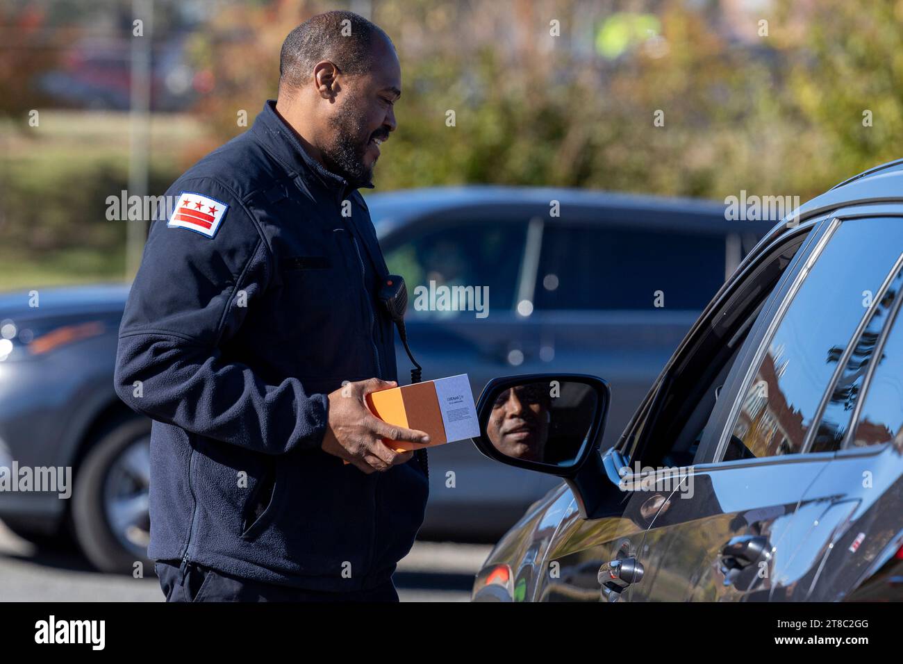 Kareem Campbell distributes dashboard cameras to a driver during an ...