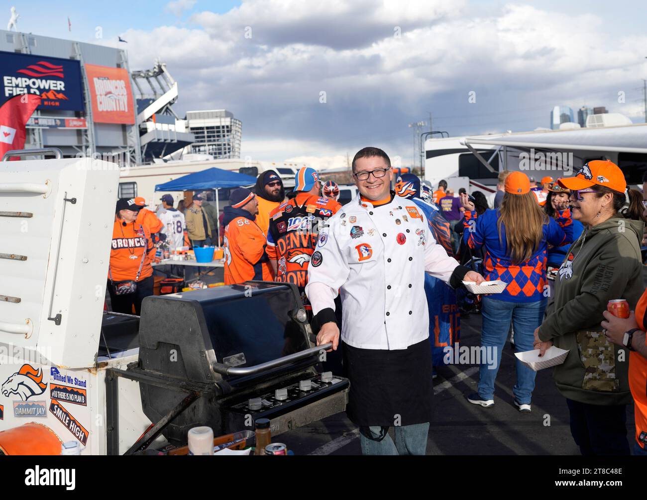 Nathan Hocking, center, of Pueblo, Colo., serves Denver Broncos fans at ...