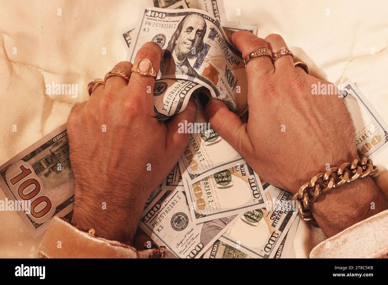 Hands of a wealthy man, adorned with golden rings and a striking black ...