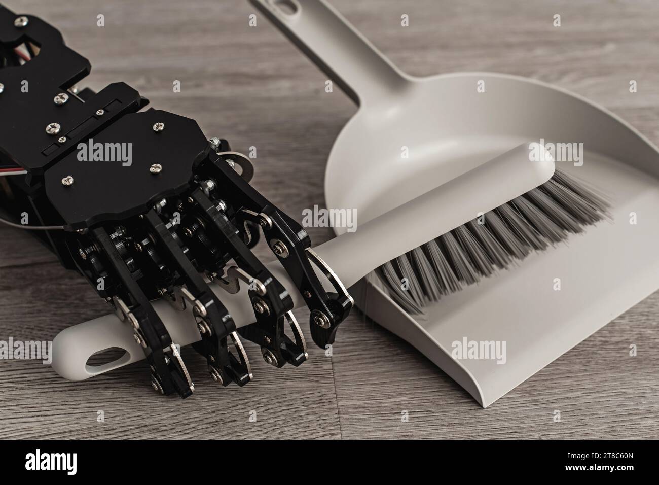 Robotic hand skillfully using a dustpan and brush to sweep the floor ...