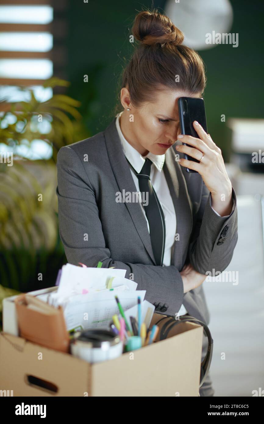 New job. unhappy modern female employee in modern green office in grey ...