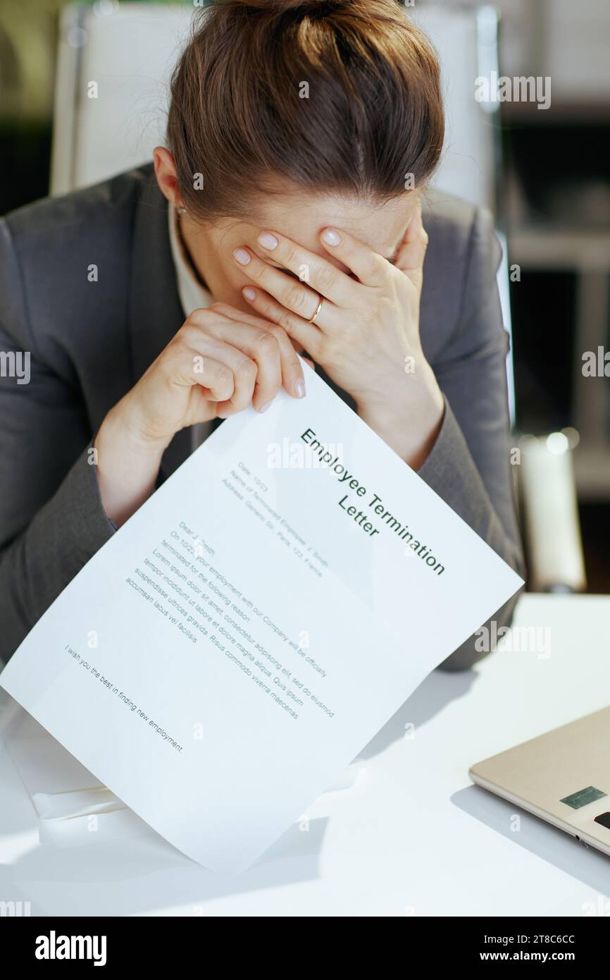 New job. sad modern female worker in modern green office in grey ...