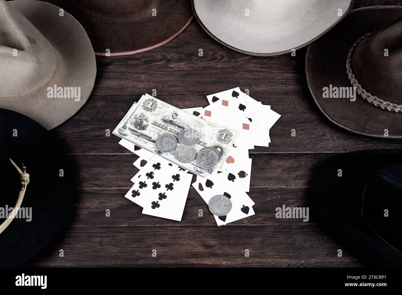 Old west hats with playing card with papers money and silver coins on ...