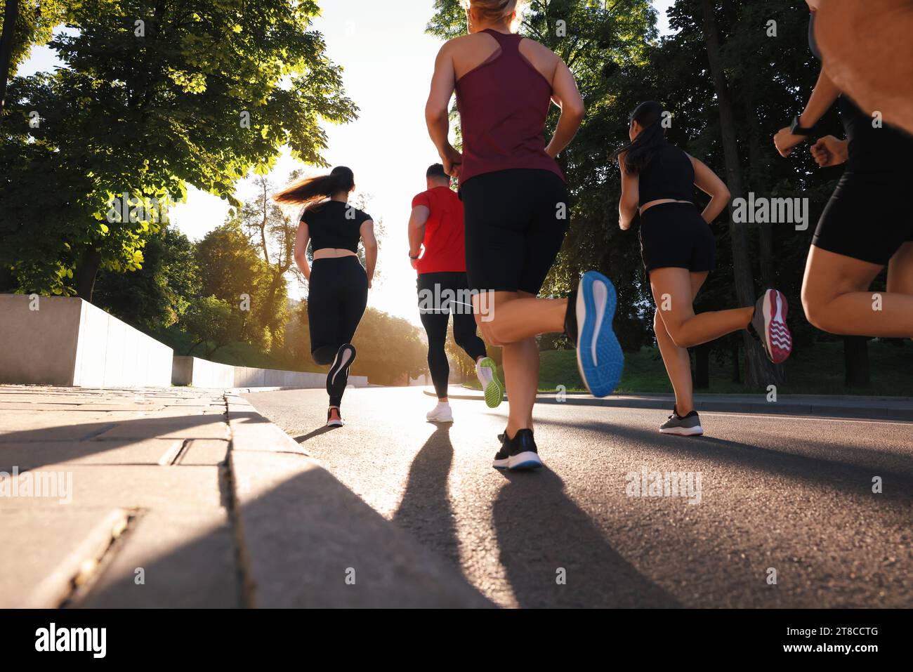 Group of people running outdoors on sunny day, back view Stock Photo ...