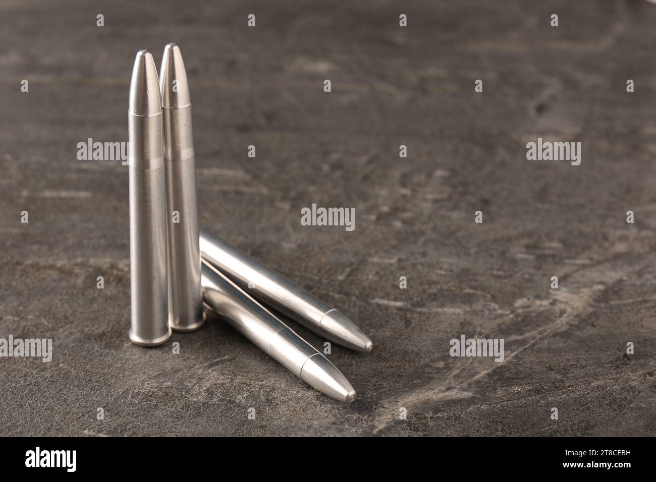 Metal bullets on dark textured table, space for text Stock Photo - Alamy