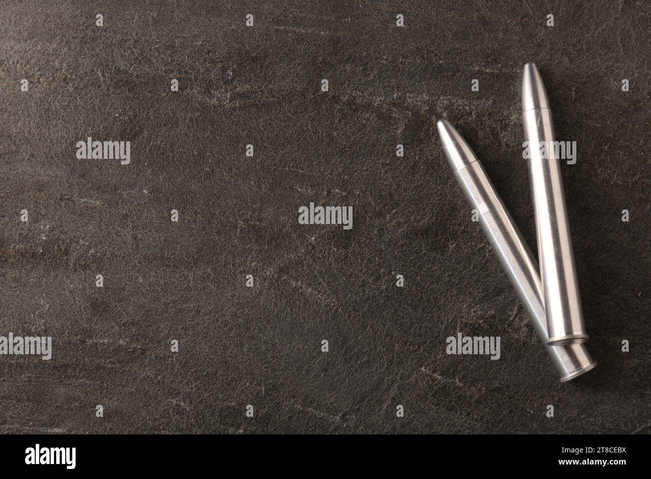 Metal bullets on dark textured table, flat lay. Space for text Stock ...
