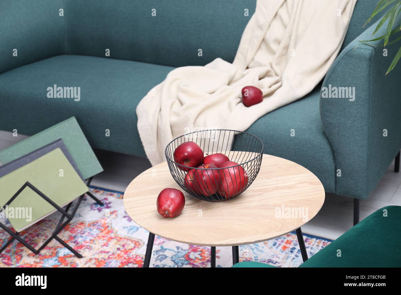 Red apples on side table near sofa in living room Stock Photo - Alamy