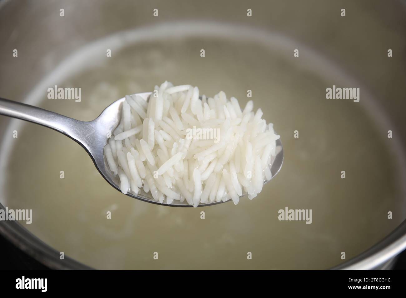 Spoon with cooked rice over pot, closeup Stock Photo - Alamy