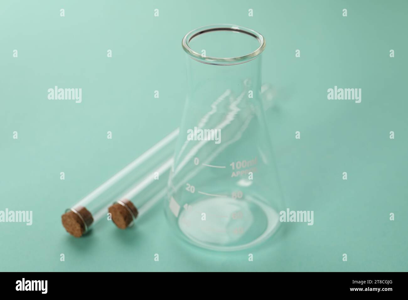 Flask and test tubes on turquoise background. Laboratory glassware ...