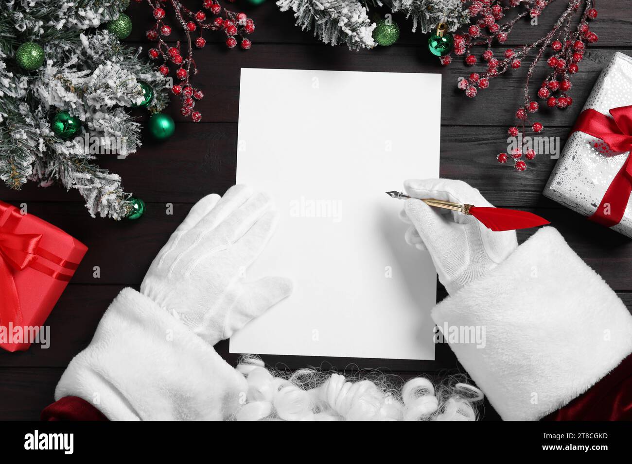 Santa Claus writing letter with fountain pen at wooden table, top view ...