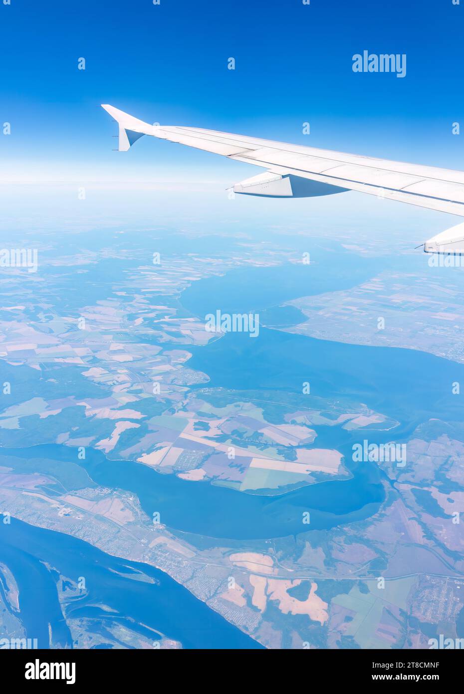 Aerial view from airplane window above green ground. View from the ...