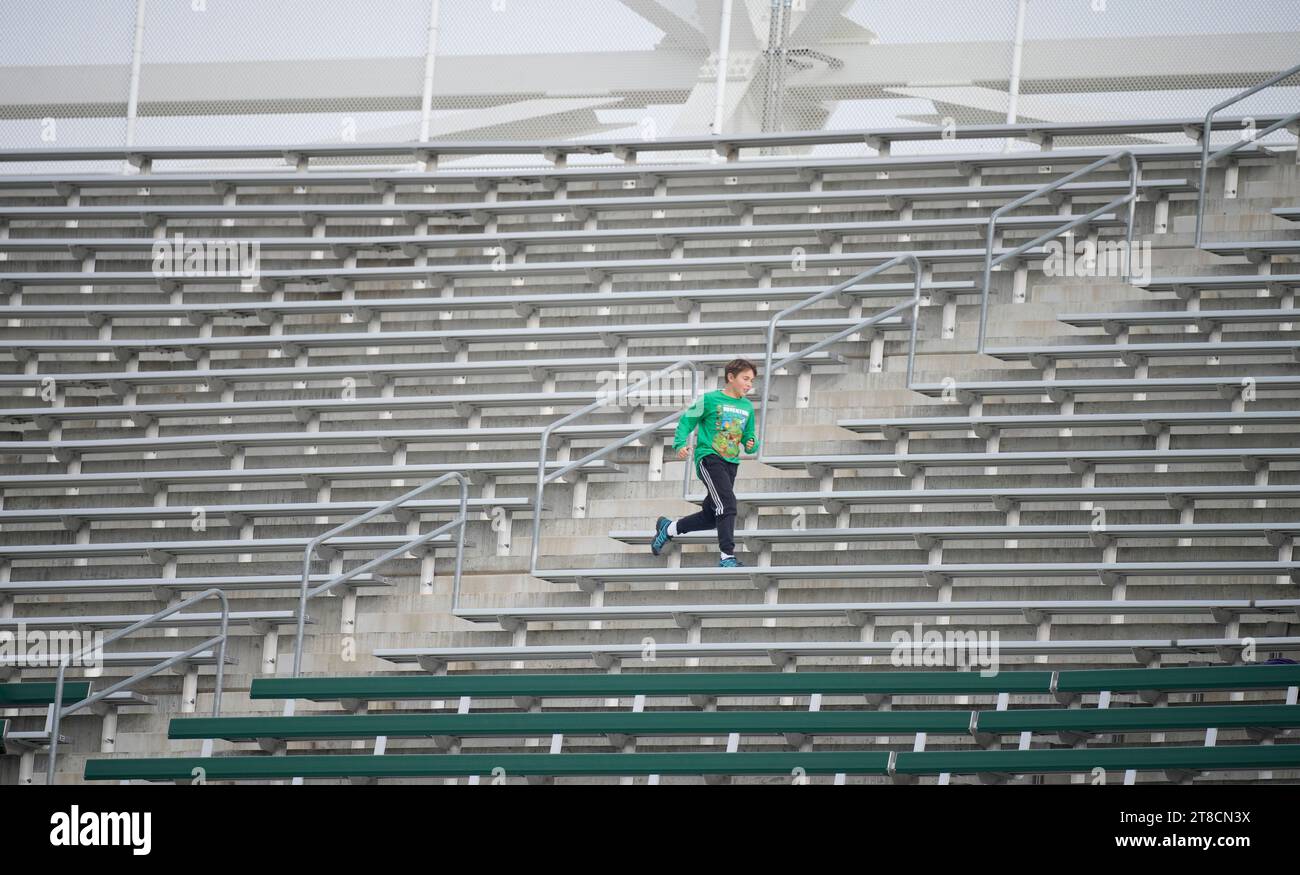 A boy runs through the empty bleachers in the upper deck of Canvas ...