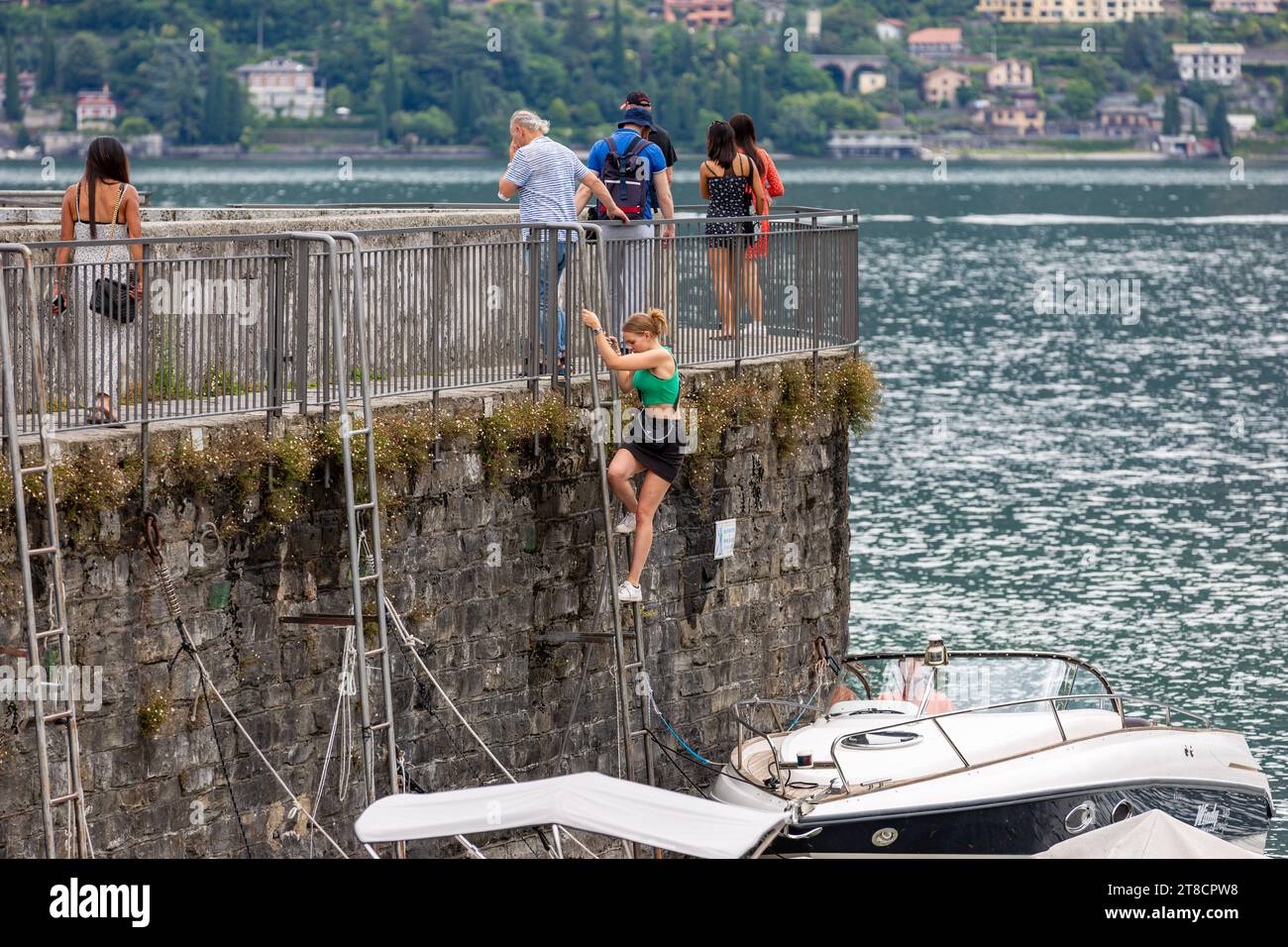 A woman climbs a ladder from a jetty to her speedboat inconveniently ...