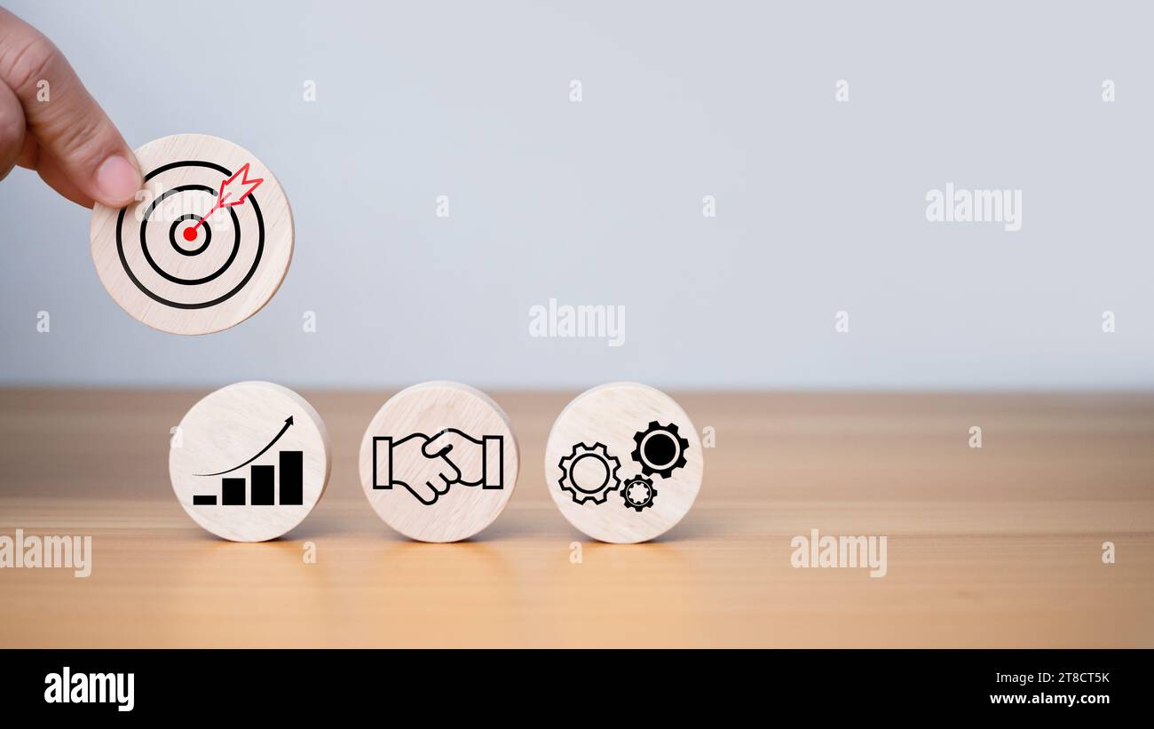 Businessman's hands hold a circular wooden board with printed target ...