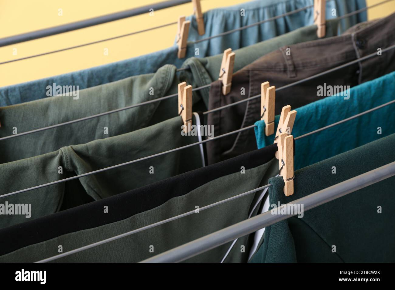 Clean green clothes hanging on dryer, closeup Stock Photo - Alamy