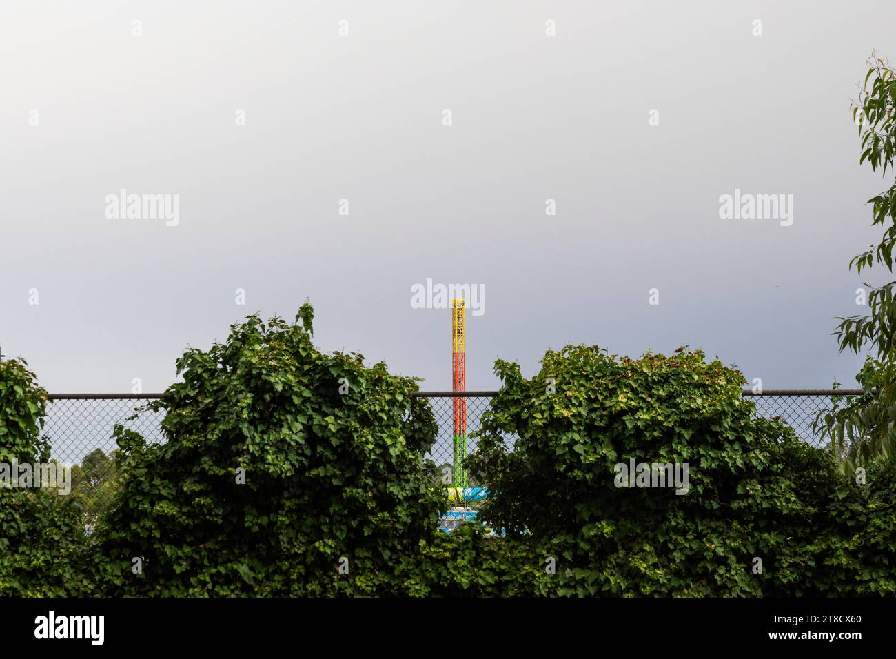 Theme park ride towering over a fence, promising adventure and ...