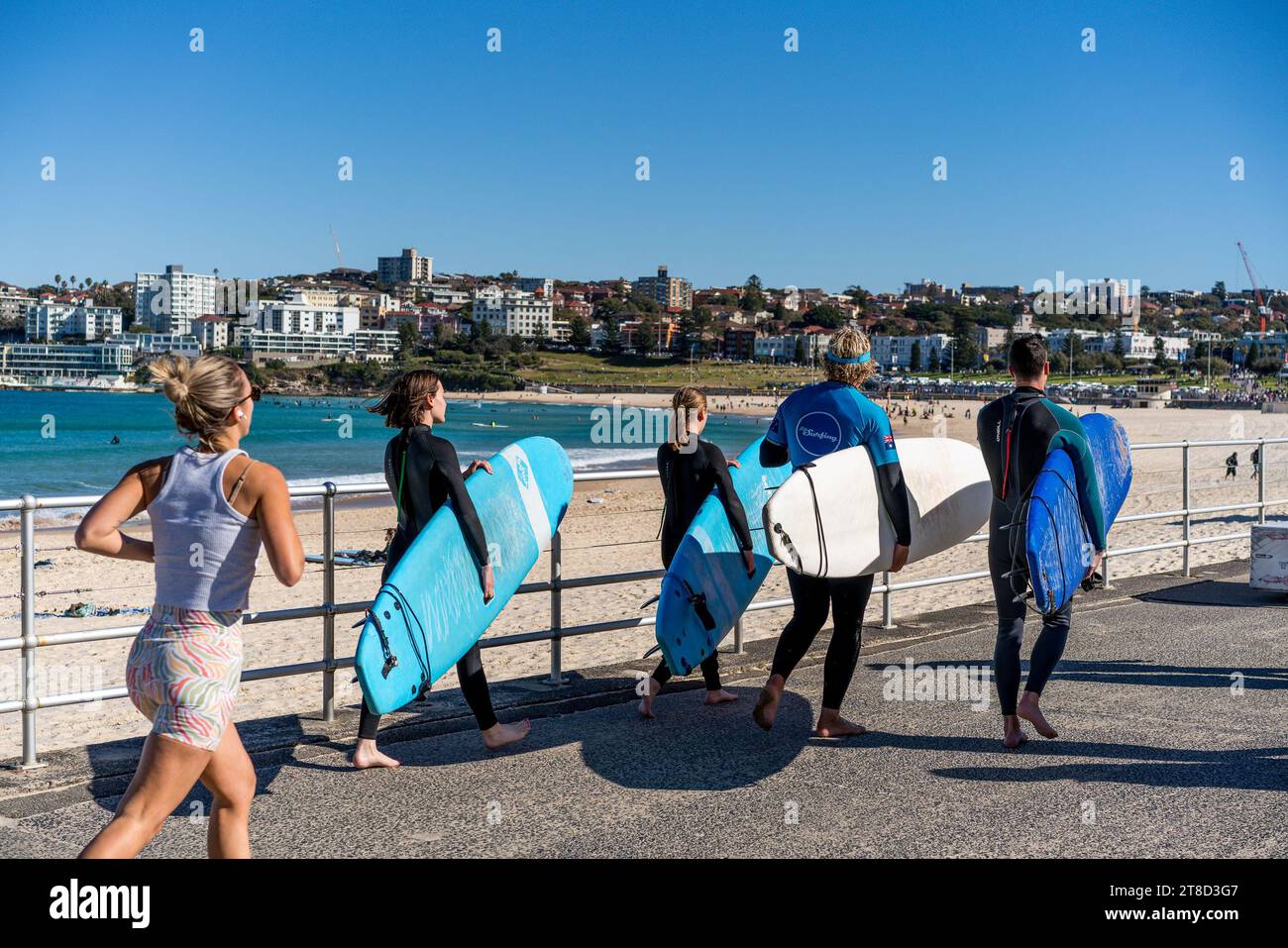 Young surfers carry their boards along the promenade at Cronulla Beach ...
