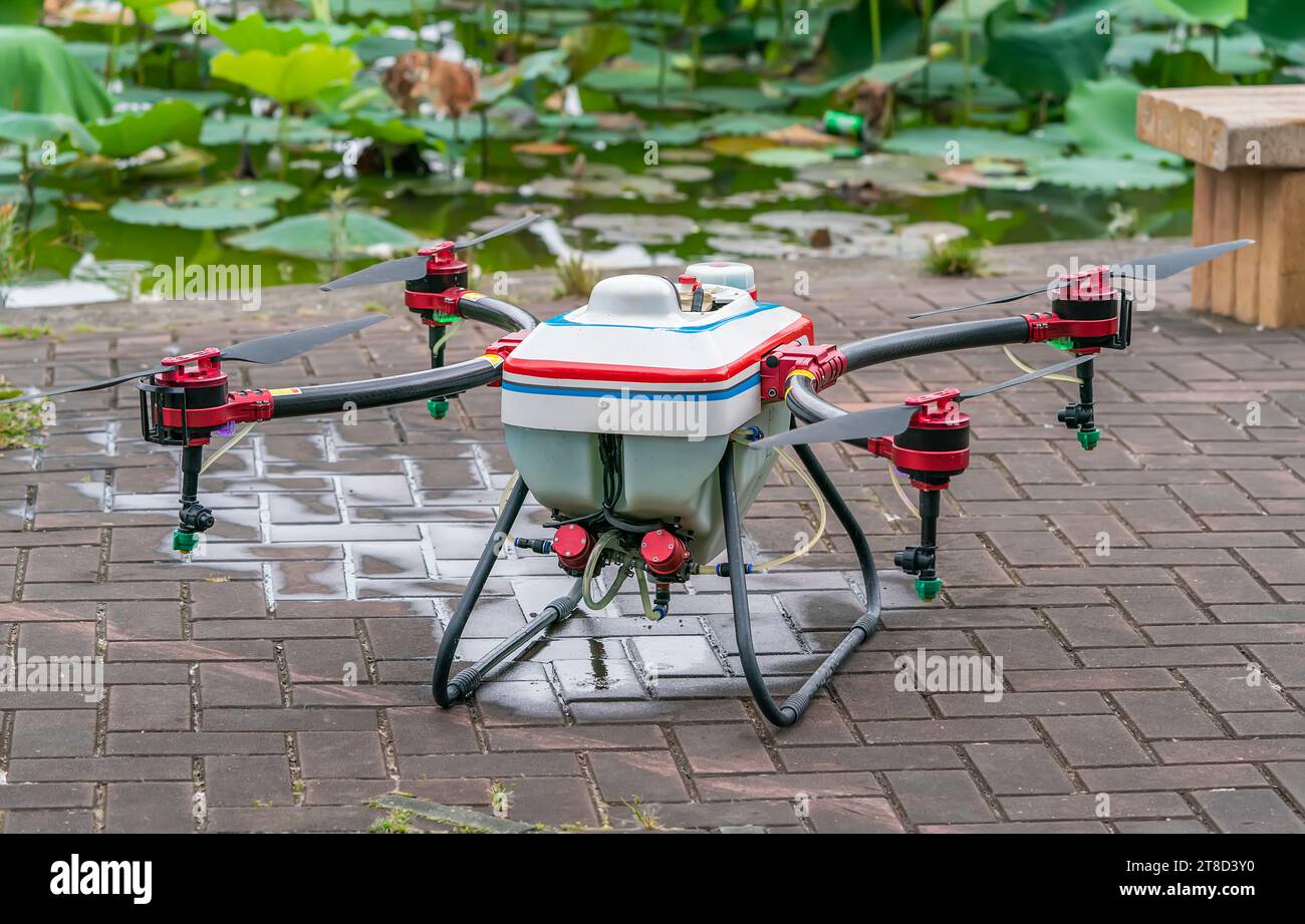 agriculture drone carry a tank of liquid fertilizer flying in the blue ...
