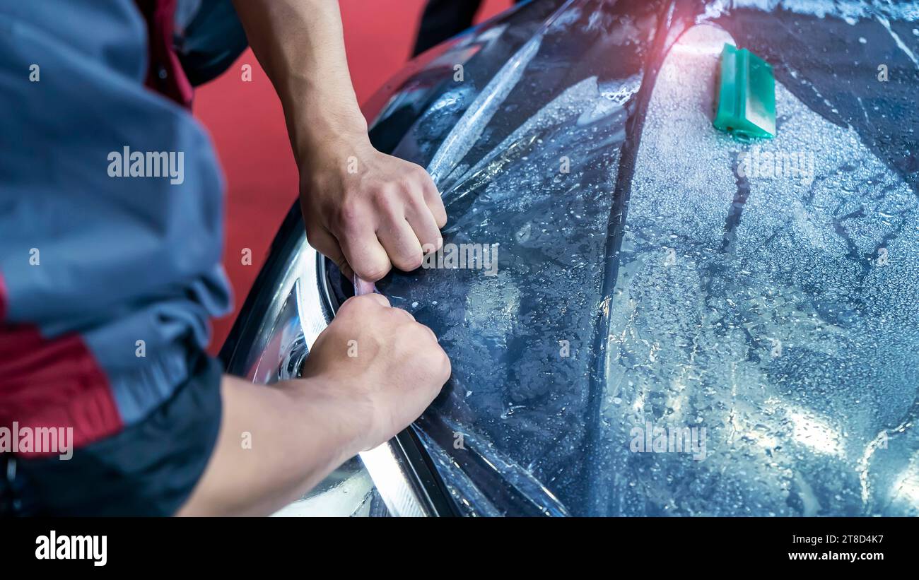 Worker install car paint protection film with spatula Stock Photo - Alamy