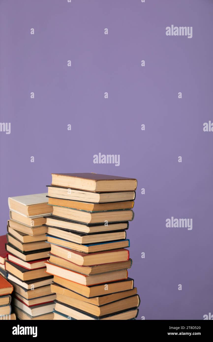 stack of books library for reading and education on a purple background ...