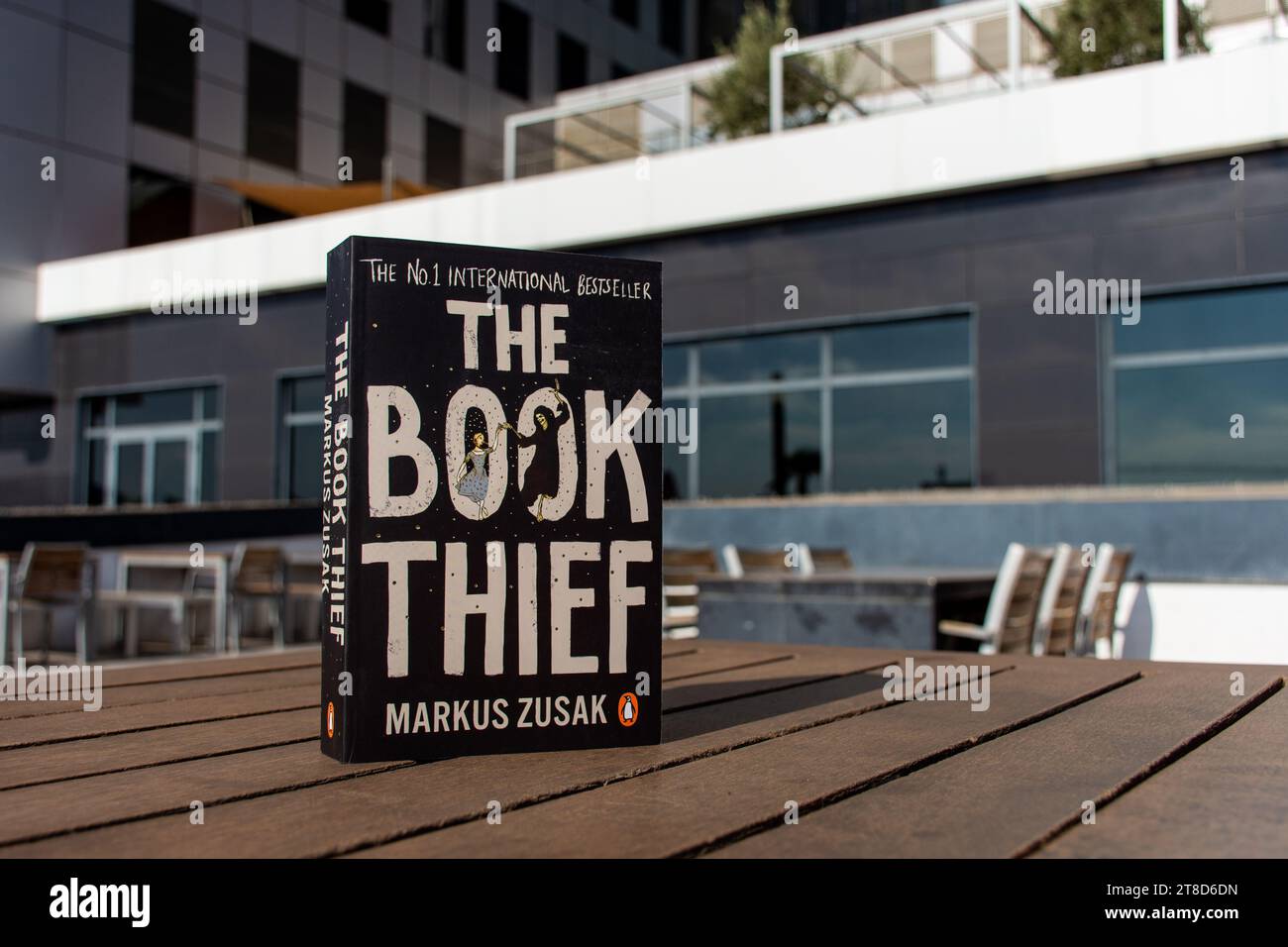 Close-up Markus Zusak's The Book Thief book on a wooden table. Young ...
